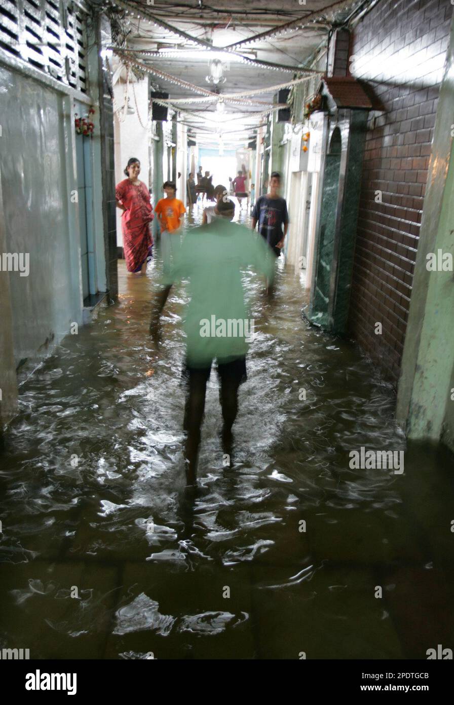 People wade through a flooded corridor as heavy rain lashed the city of ...