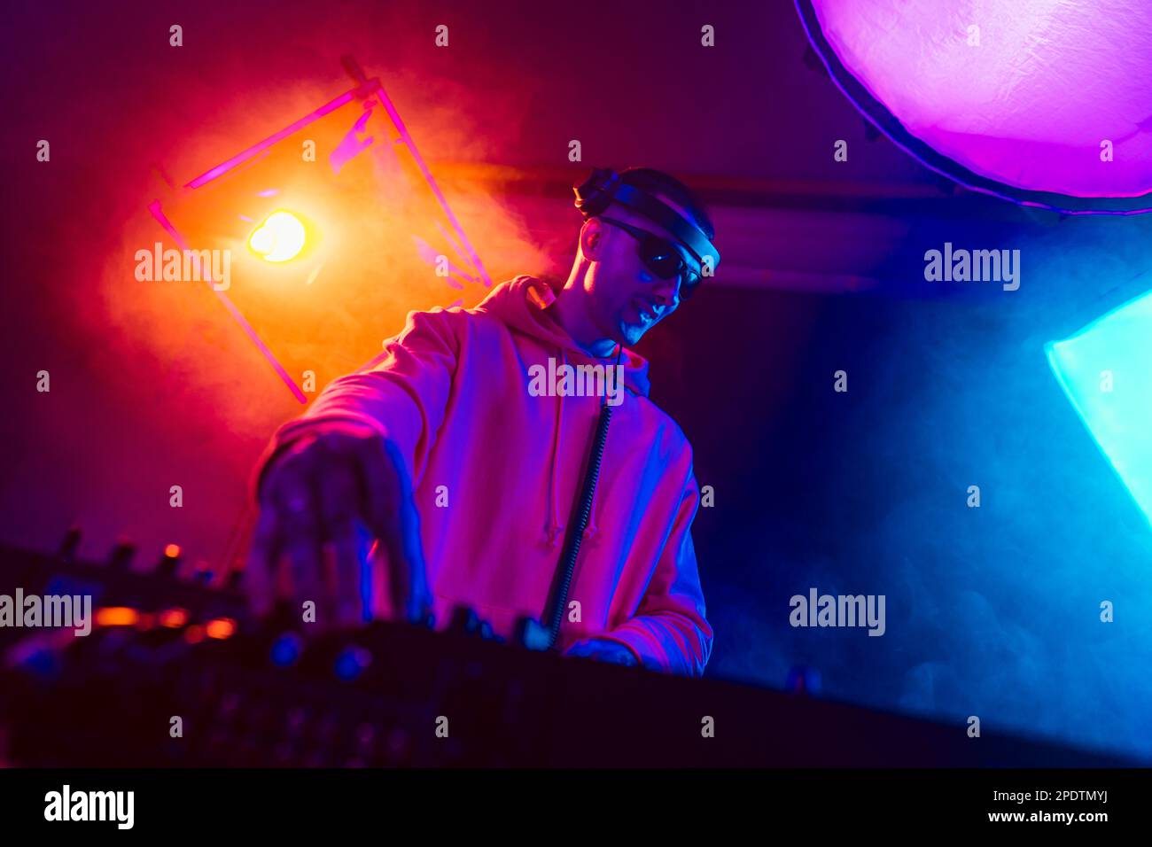 Male DJ playing music in the night club Stock Photo - Alamy
