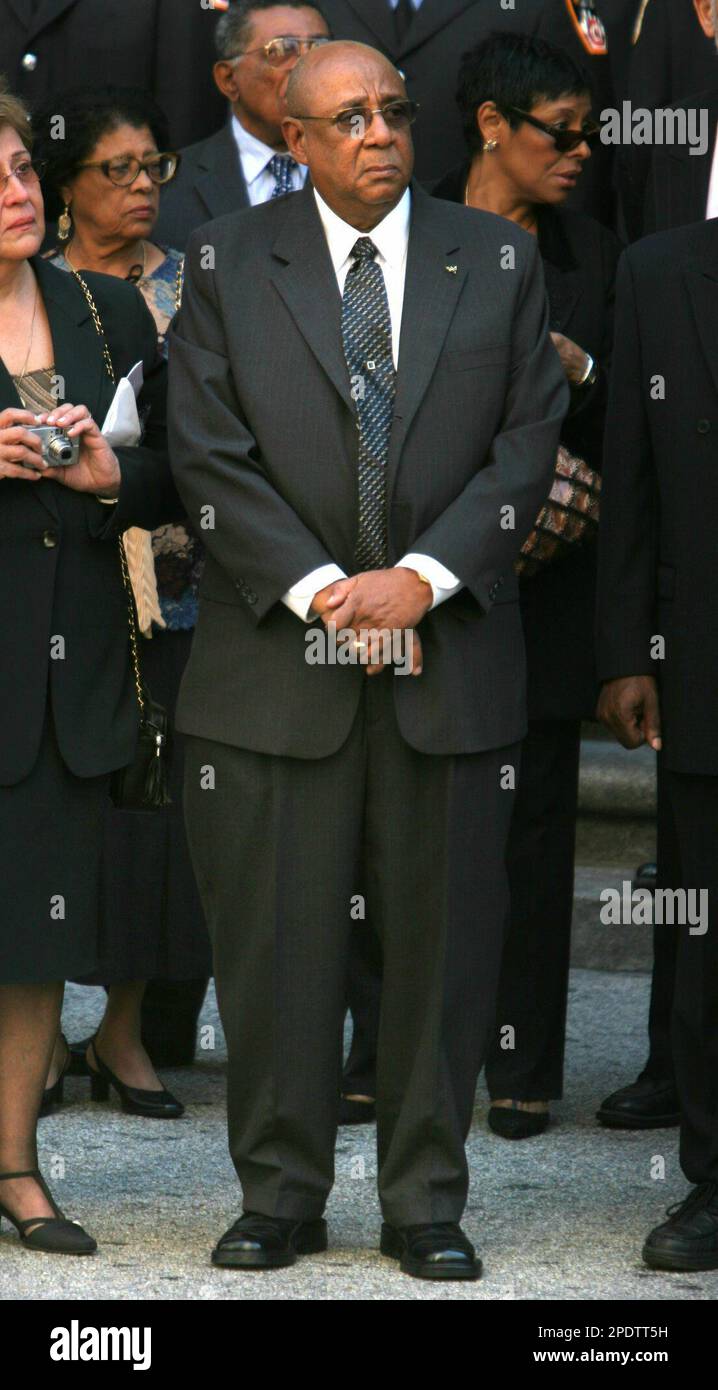 Gerard Jean-Baptiste, center, watch as the casket carrying the remains ...
