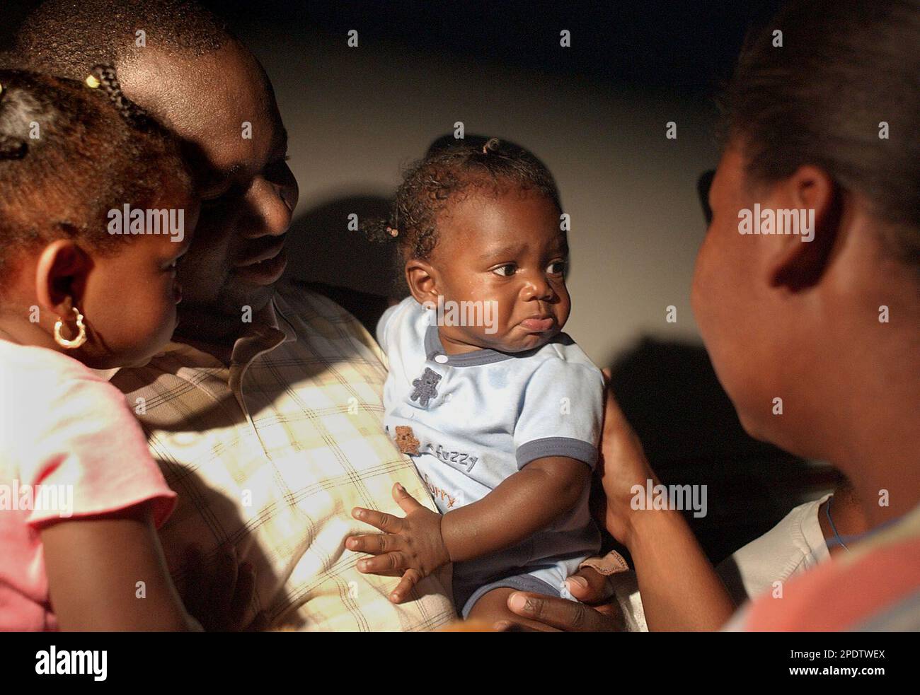 A'Mahd Magee, center, 7 months old, is greeted by his father, Robert ...