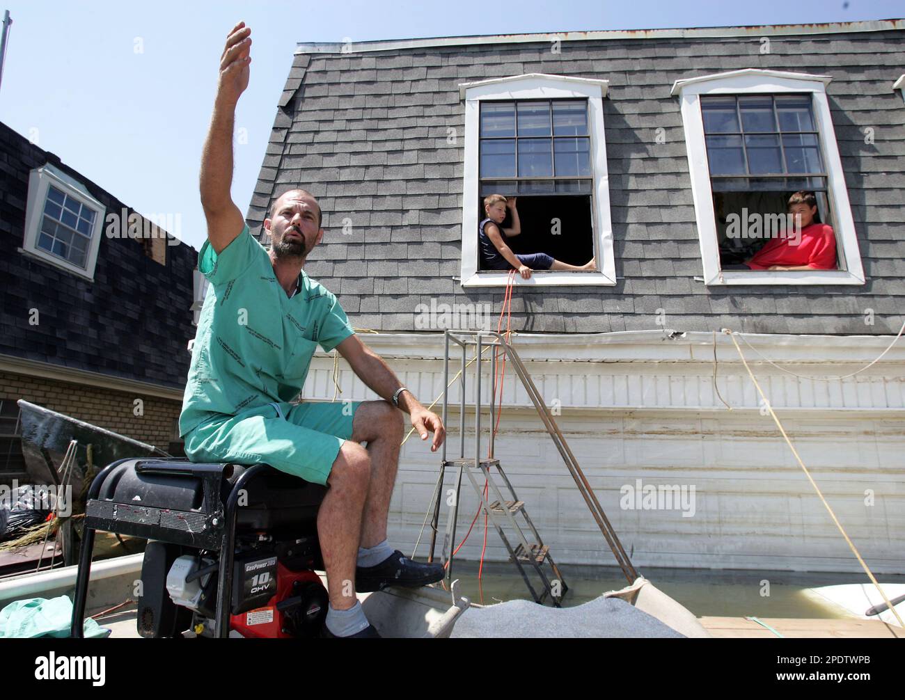 Dennis Rizzuto, 38, gestures to his home and belongings as he sits ...