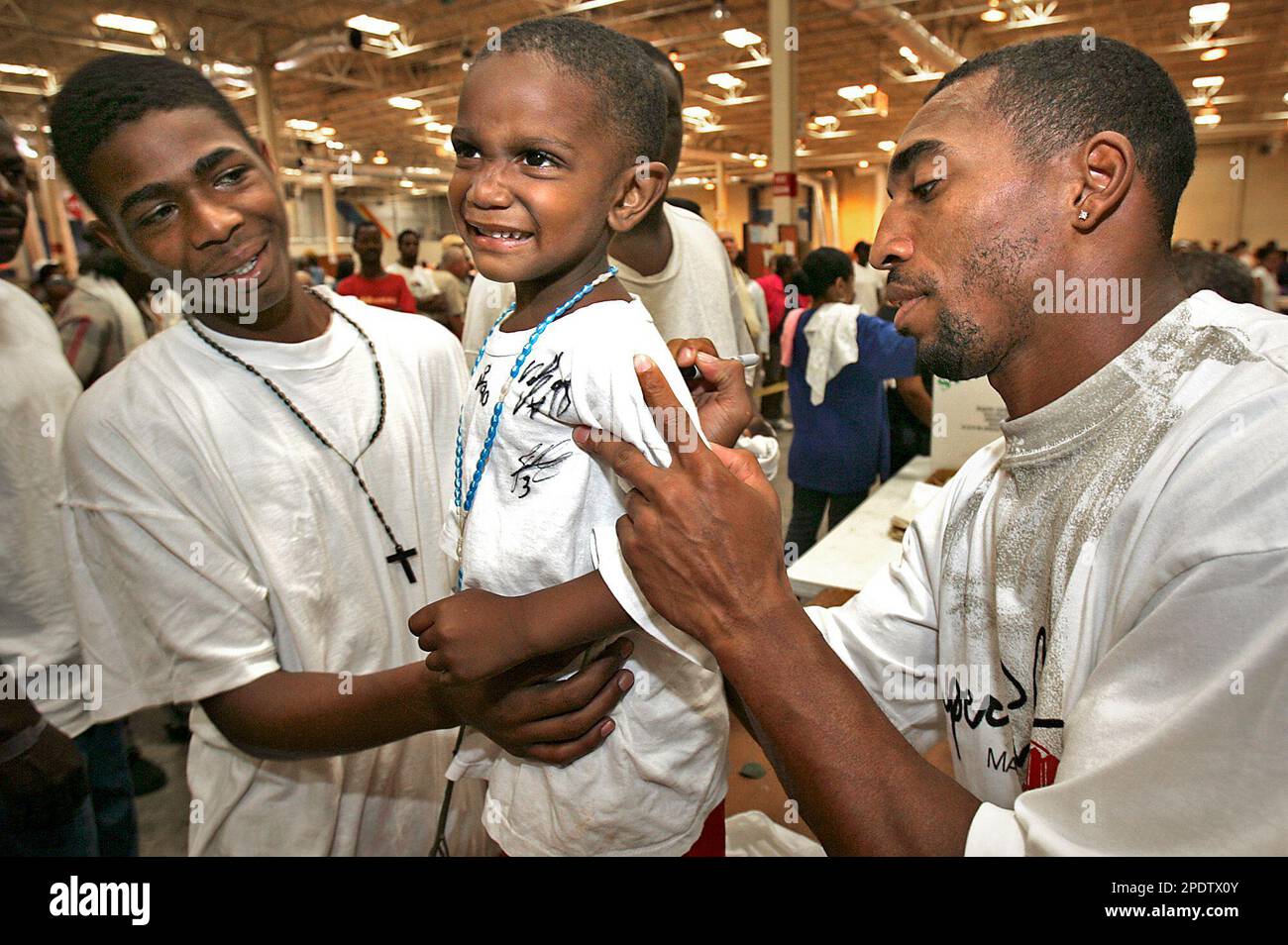 Brian Reaux, left, holds his 2-year-old brother, Cyrus Reaux, center ...