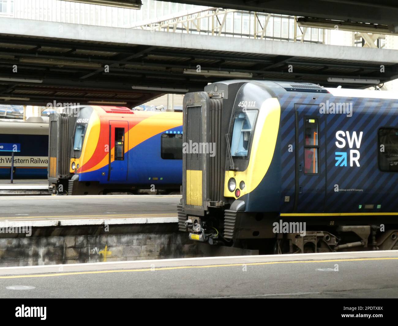 Waterloo station in London with three electric trains in contrasting ...