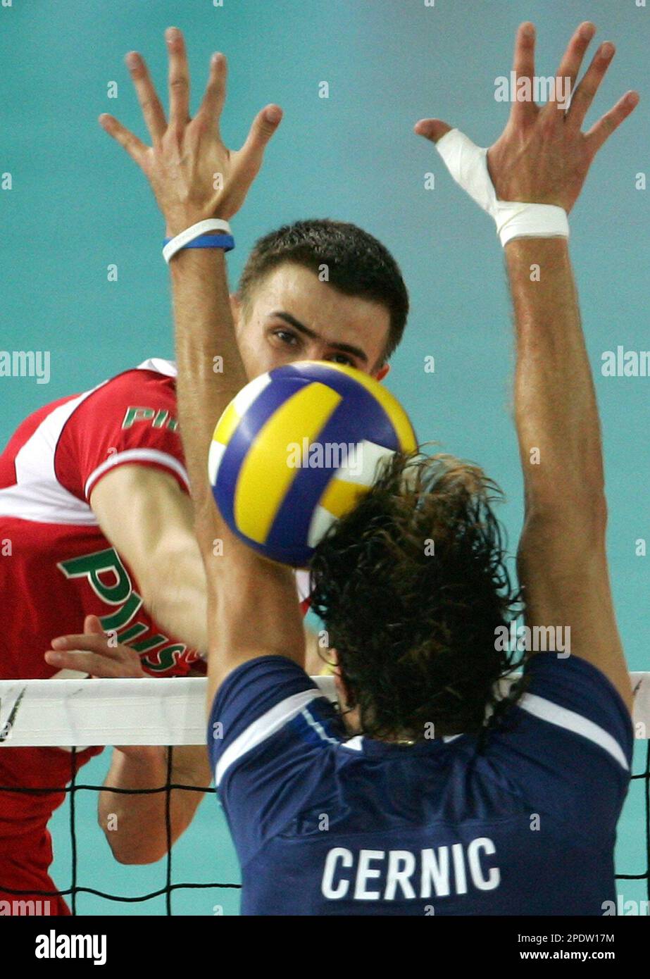 Poland's Mariusz Wlazly, left, spikes the ball against Italy's Matej ...
