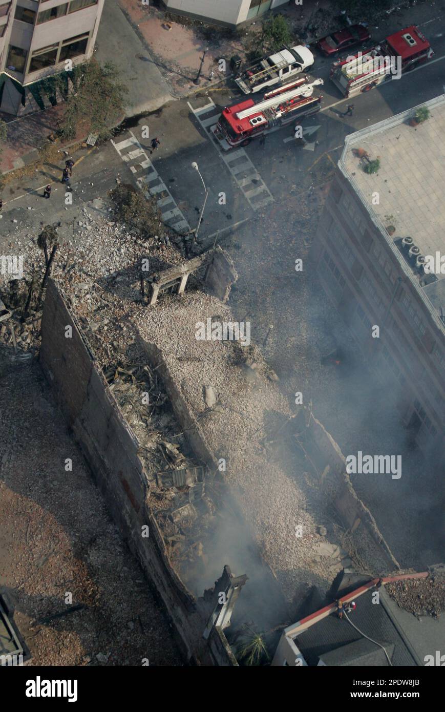 Fire trucks sit near a building which was destroyed by fire Friday ...