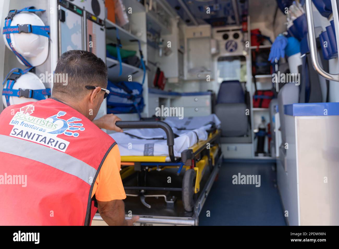 Lifeguard worker working while grabbing a stretcher on an ambulance ...