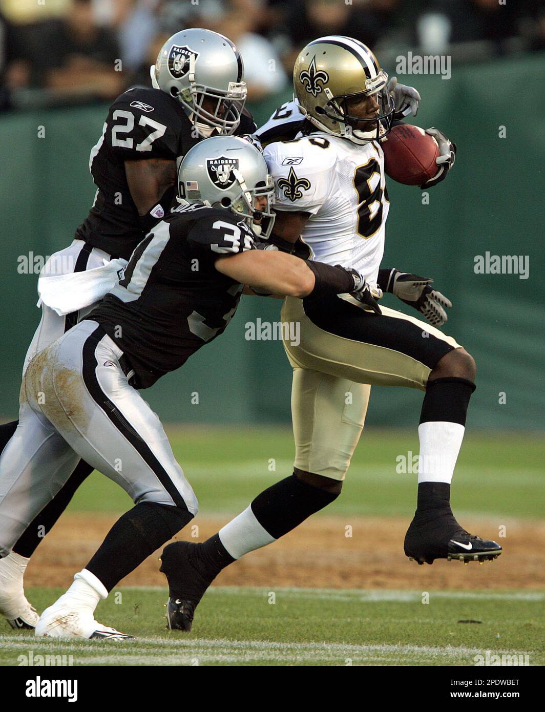 New Orleans Saints' Donte Stallworth (83) is brought down by Oakland ...