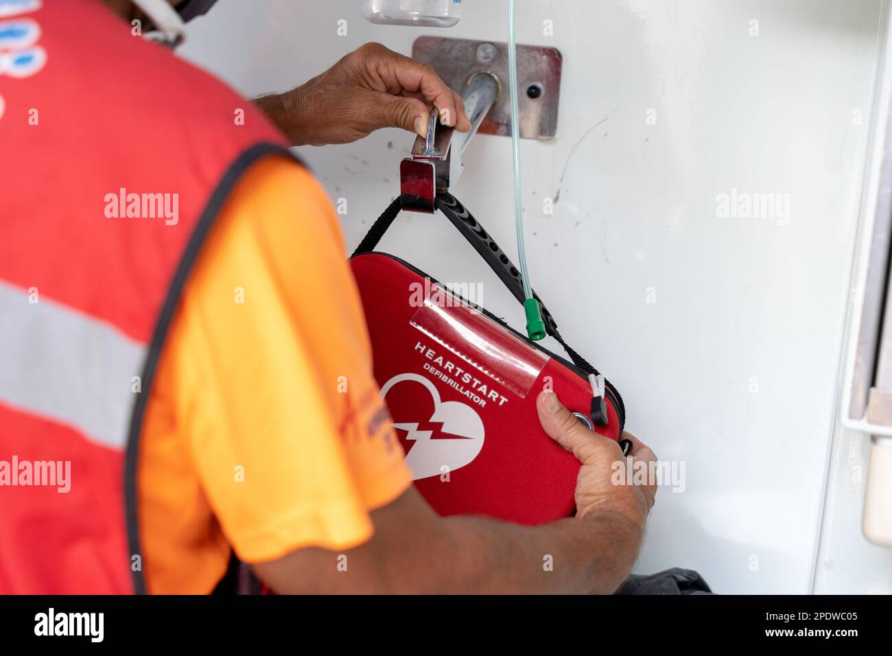 Unrecognizable first aid worker holding a defibrillator bag in an ...