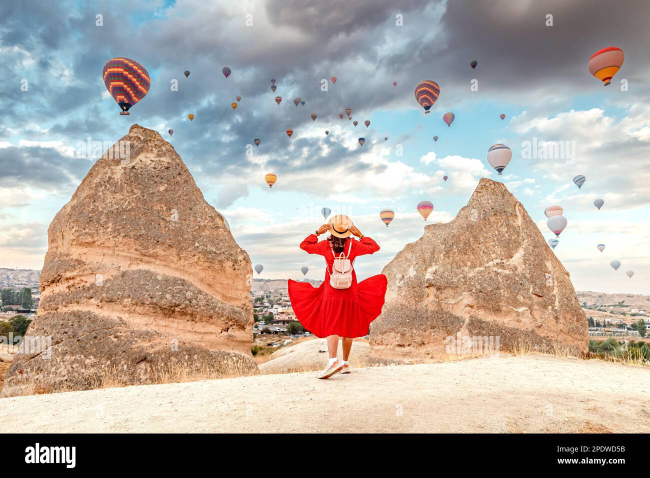 She stands in the warm summer air, dress fluttering in the breeze ...