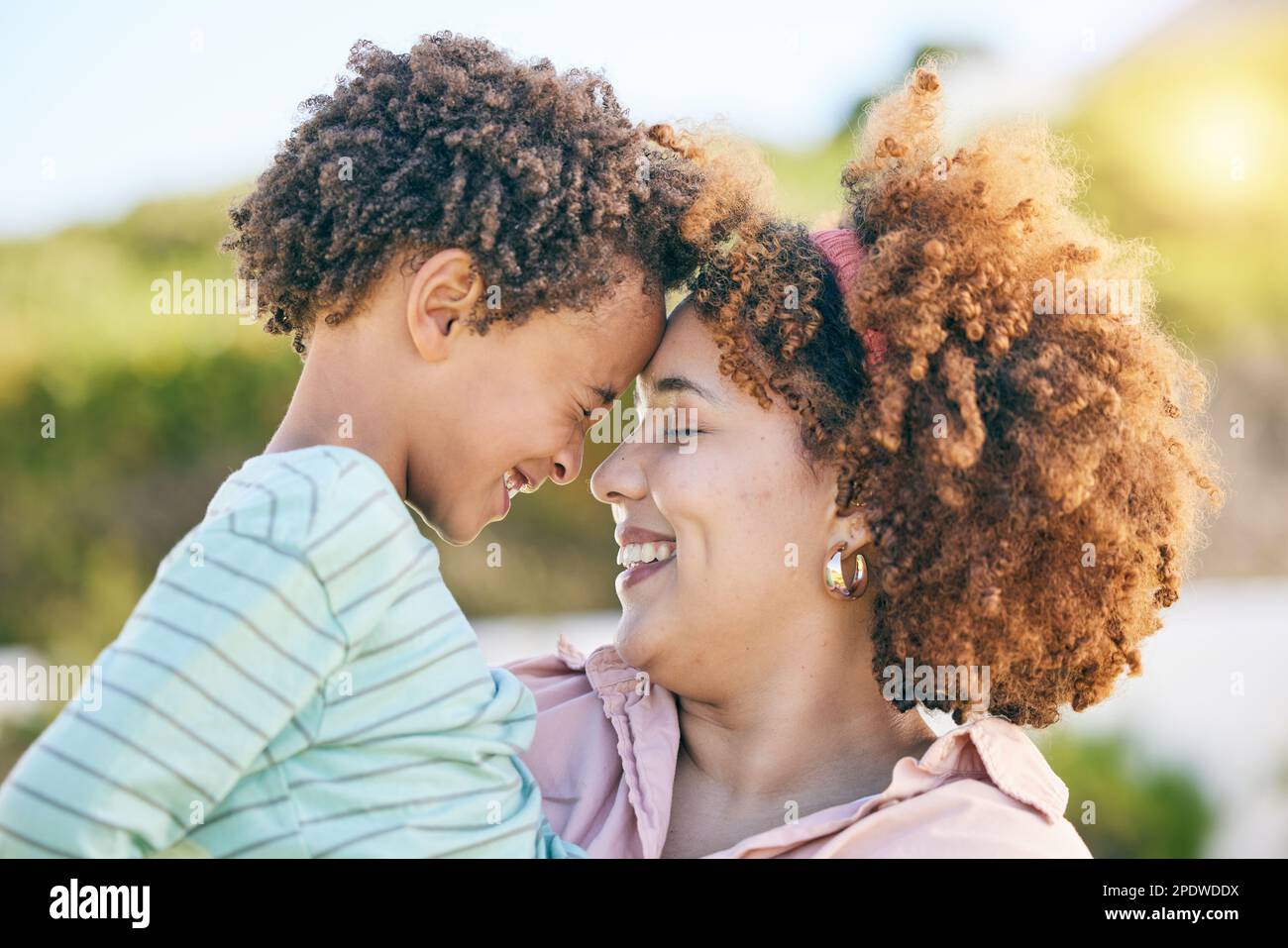 Family, happy and woman hug kid, content together outdoor and face ...