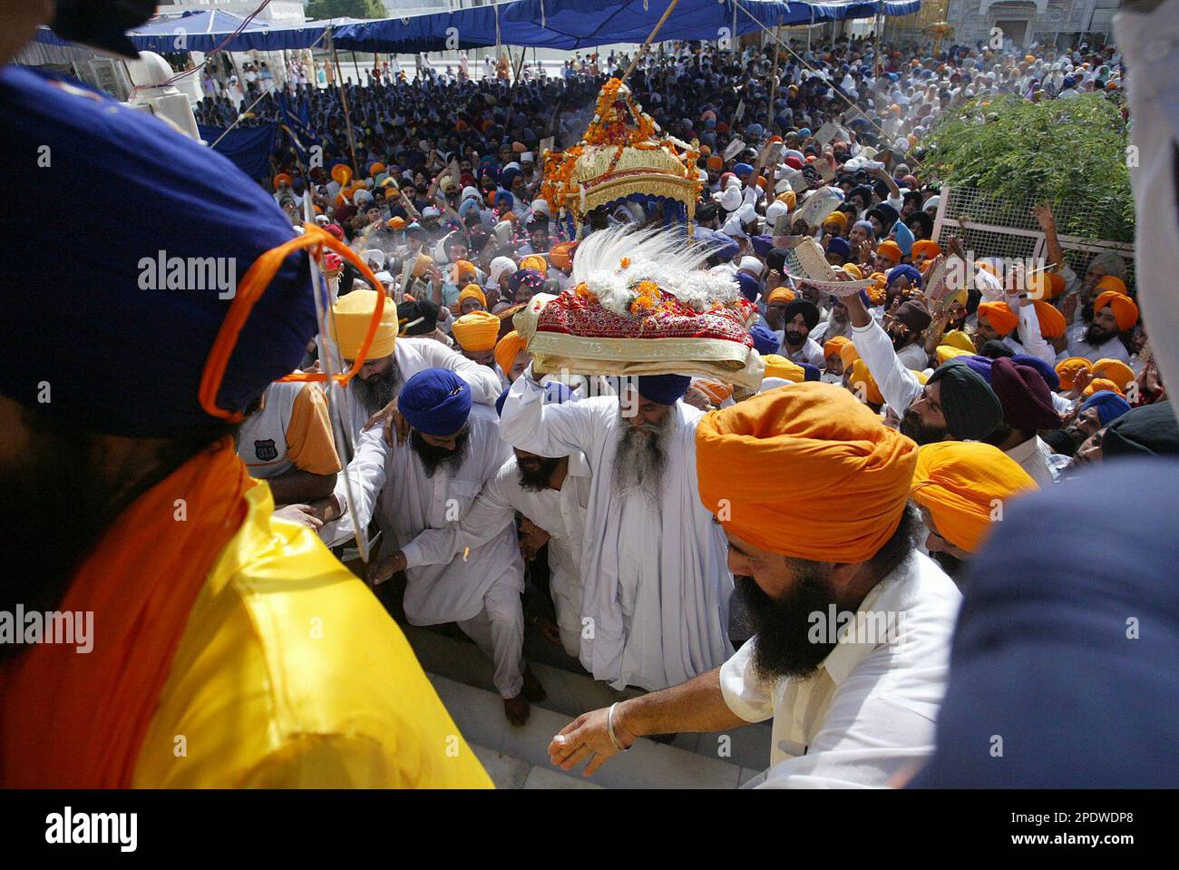 A Sikh priest carries the Guru Granth Sahib or Sikhs holy book inside the Golden Temple ...