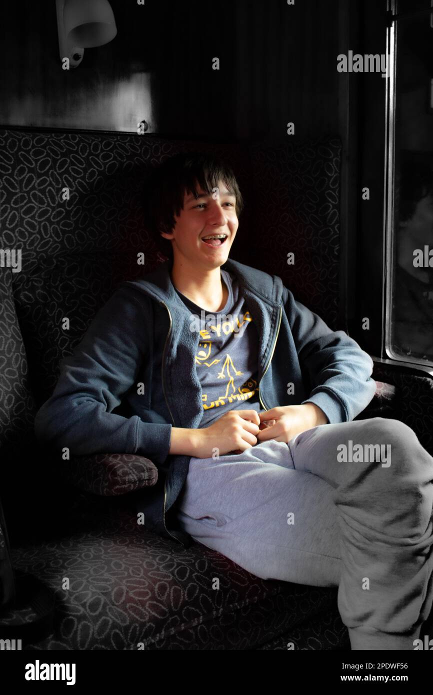 Laughing teenage boy in train carriage Stock Photo - Alamy