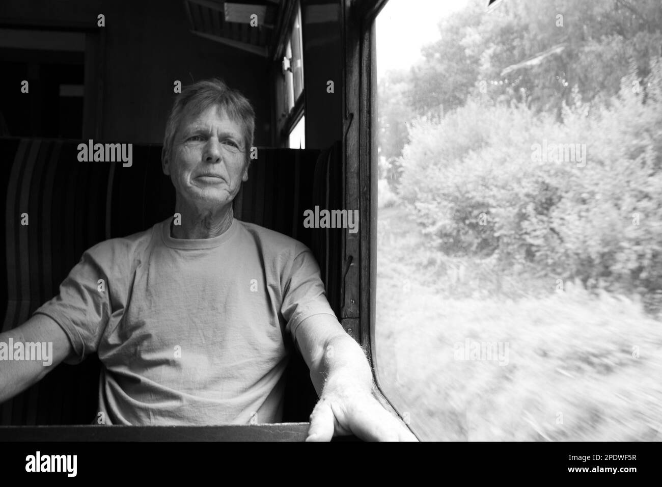 Older man sitting on vintage train in black & white Stock Photo - Alamy