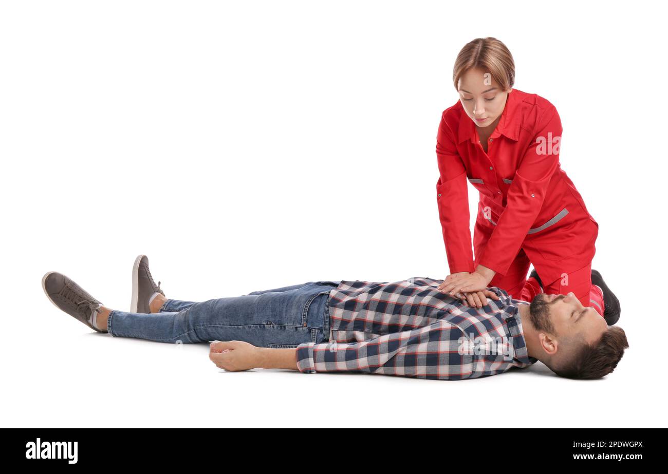 Paramedic in uniform performing first aid on unconscious man against ...