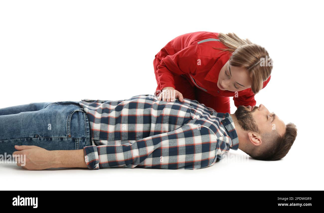 Paramedic in uniform performing first aid on unconscious man against ...