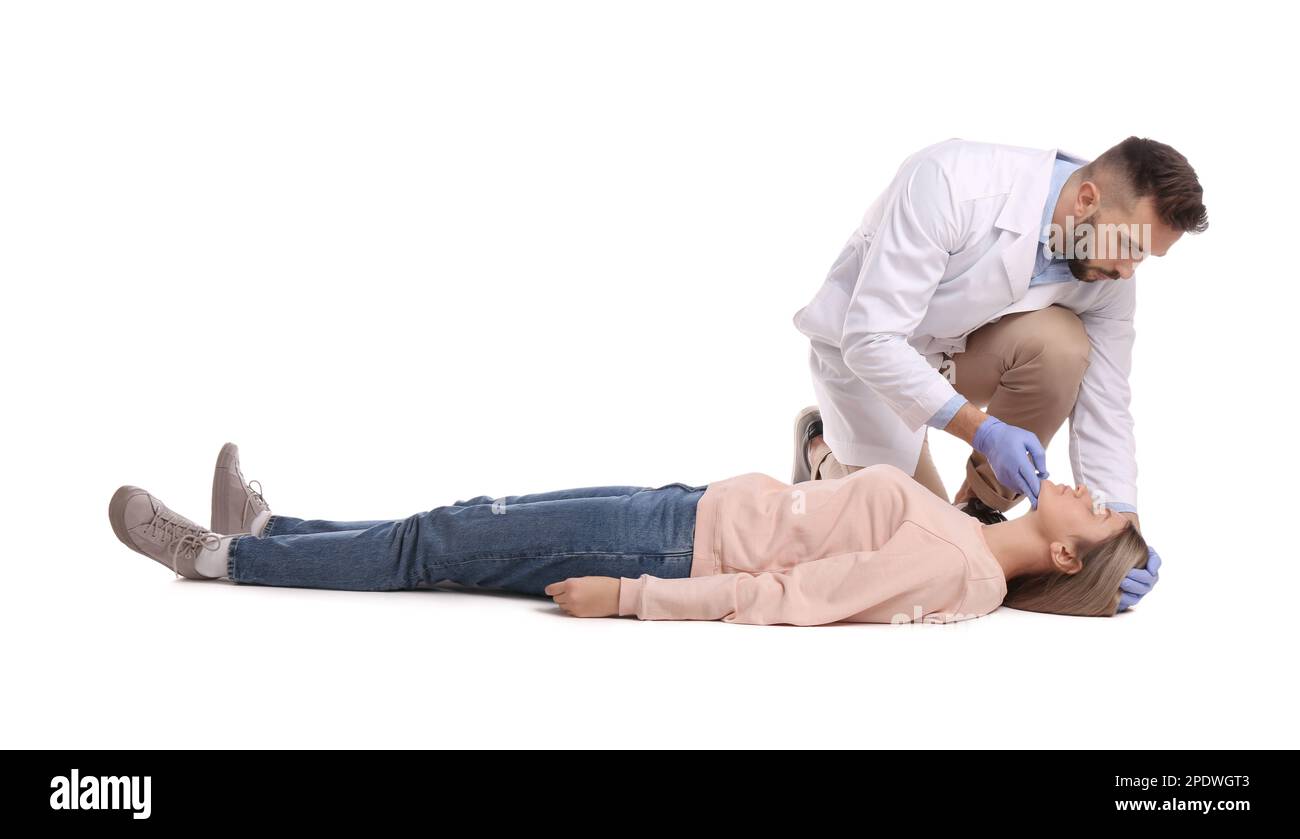Doctor in uniform performing first aid on unconscious woman against ...