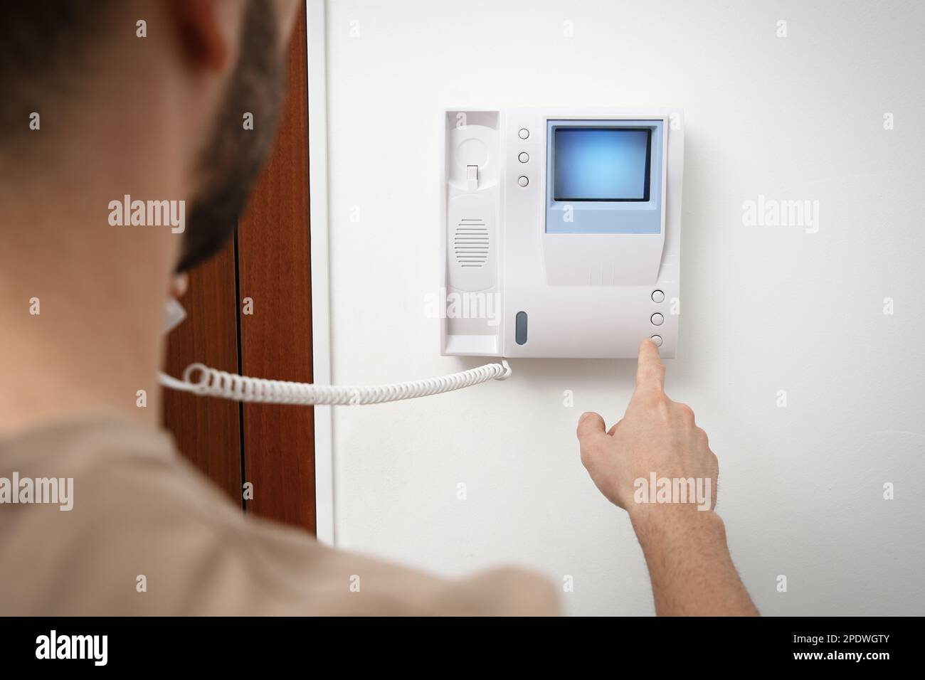 Man pressing button on intercom panel indoors, closeup Stock Photo - Alamy