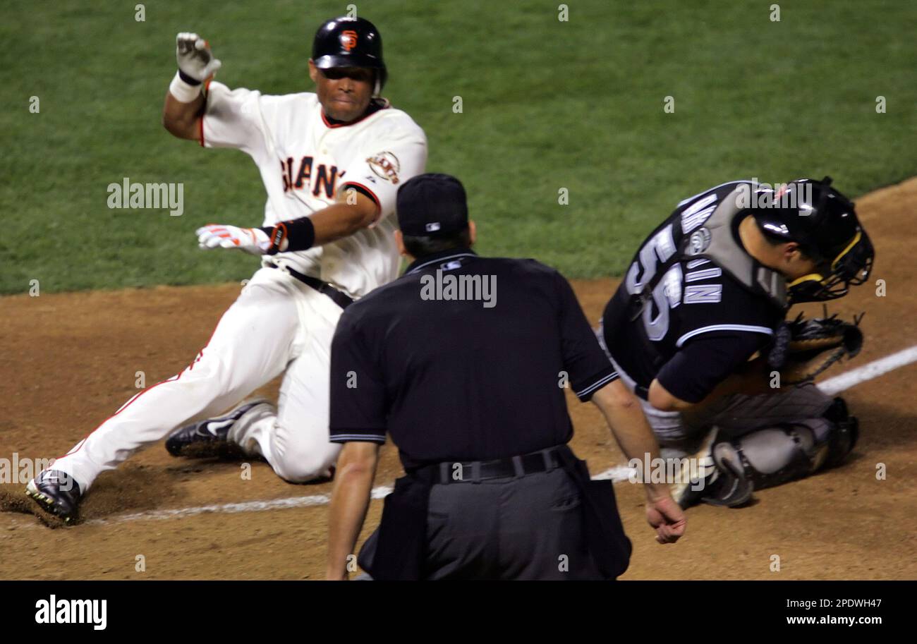 San Francisco Giants' Pedro Feliz, left, scores as Colorado Rockies ...