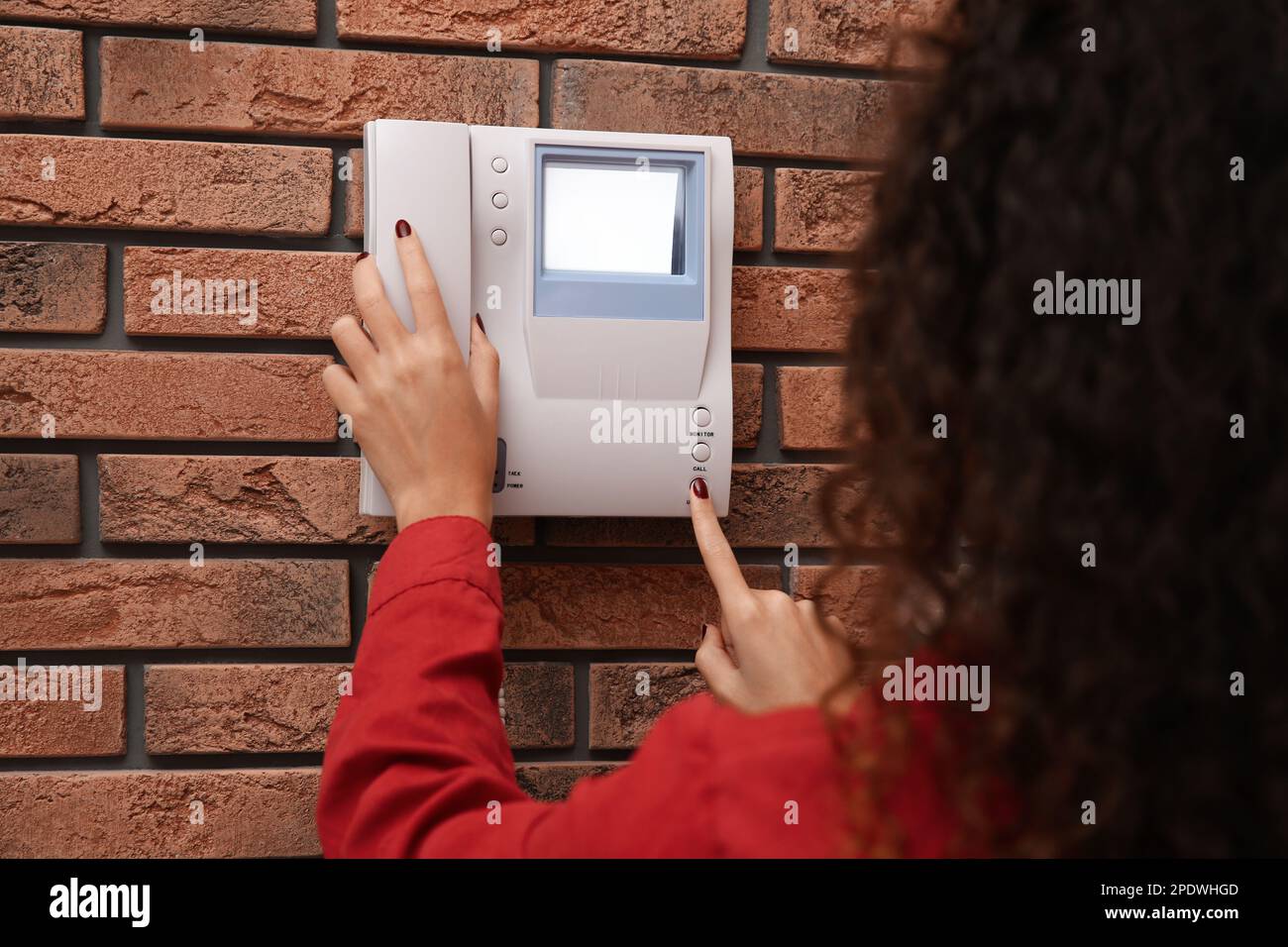 African-American woman pressing button on intercom panel indoors Stock ...