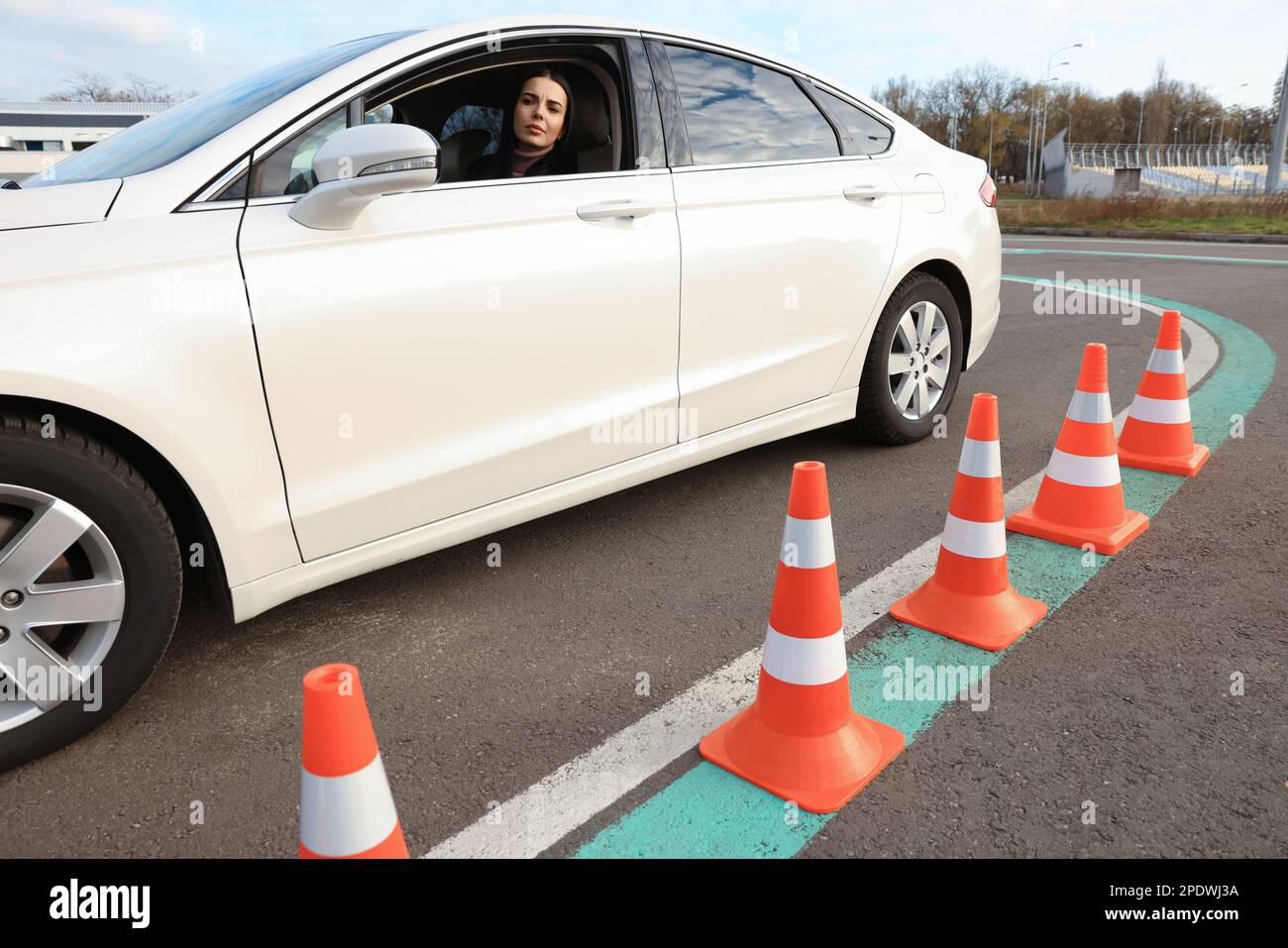 Young woman in car on test track with traffic cones. Driving school ...