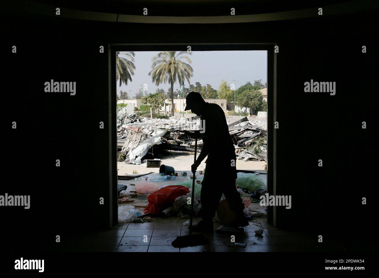 An Israeli soldier sweeps at the entrance way to the synagogue as ...
