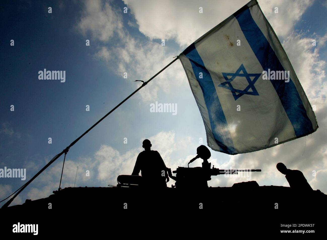 An Israeli flag flies over a Merkava tank as soldiers are seen at a ...