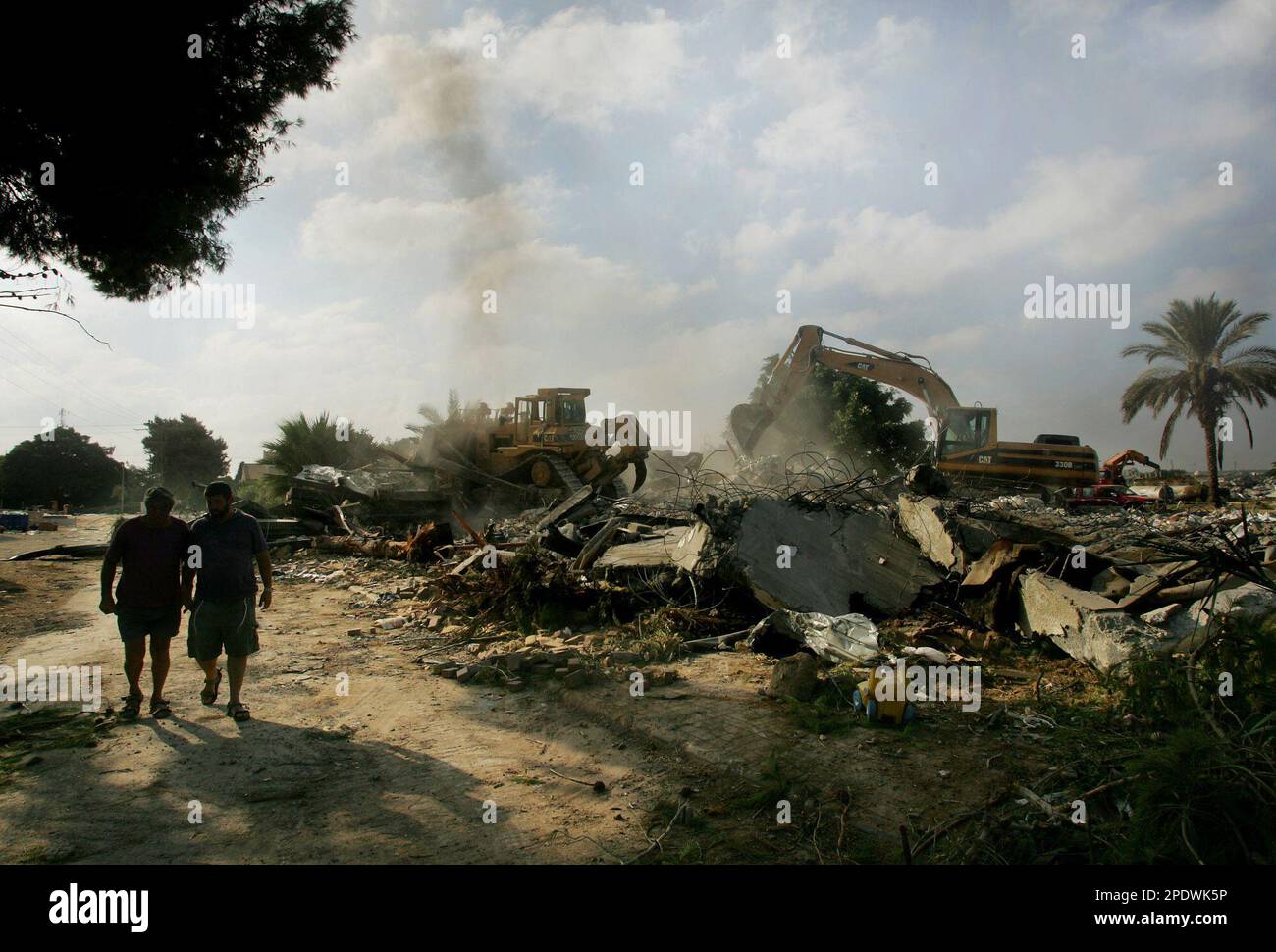 Jewish settler Oz Kadmon, right, walks with a friend as heavy equipment ...