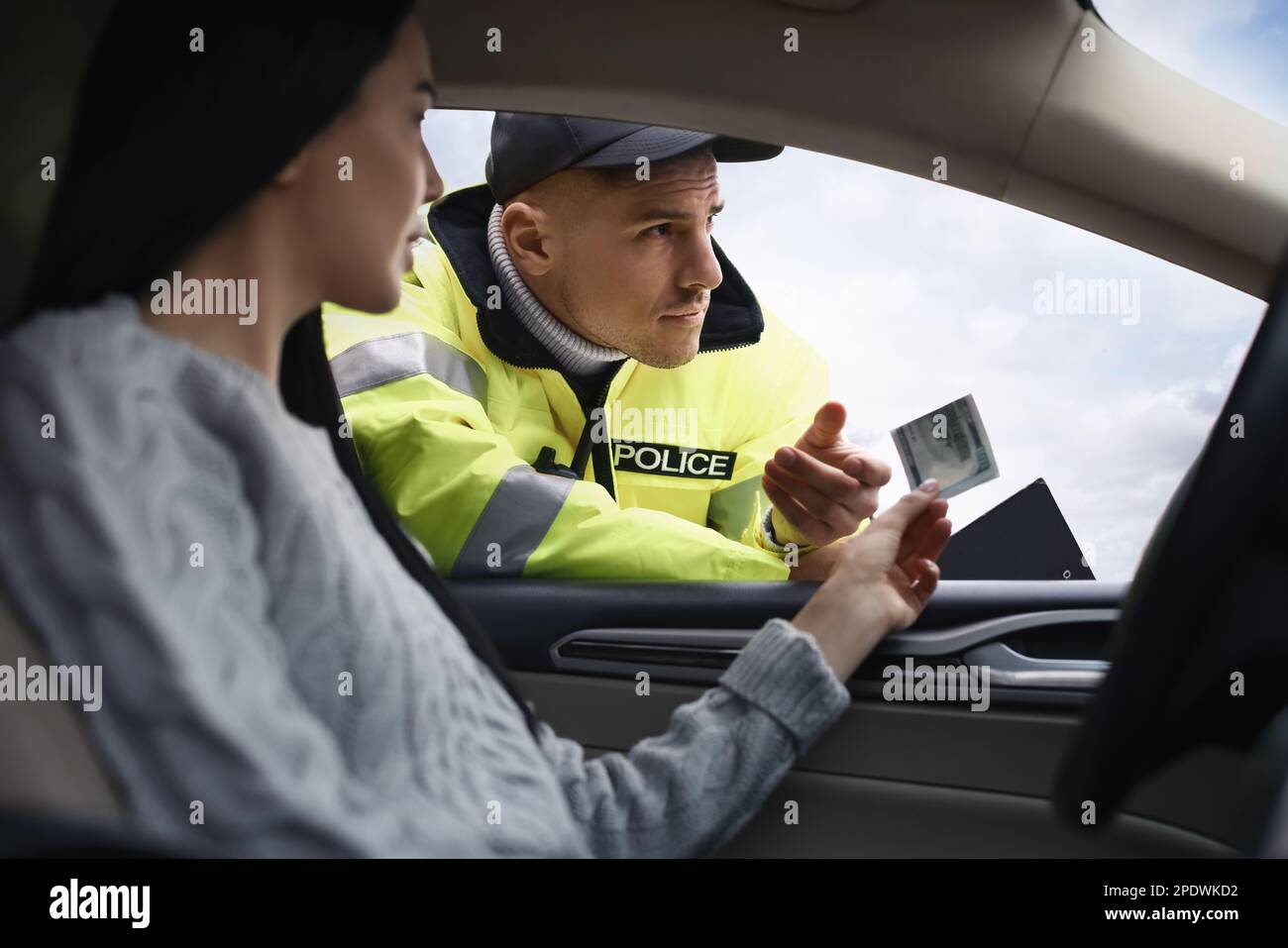 Woman giving bribe to police officer out of car window Stock Photo - Alamy