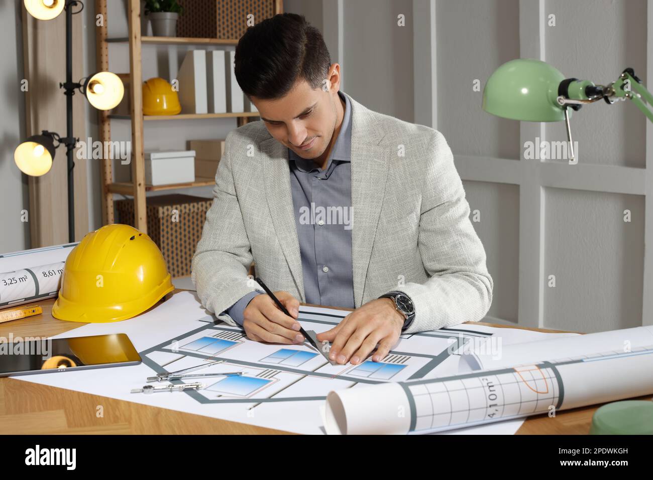 Architect working with construction drawings in office Stock Photo - Alamy