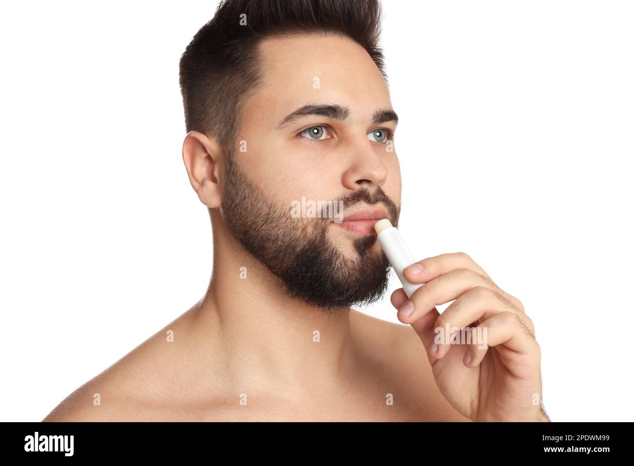Young man applying lip balm on white background Stock Photo - Alamy