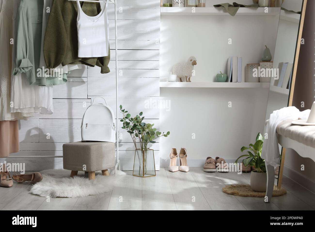 Rack with different stylish clothes, shoes and decorative elements in ...