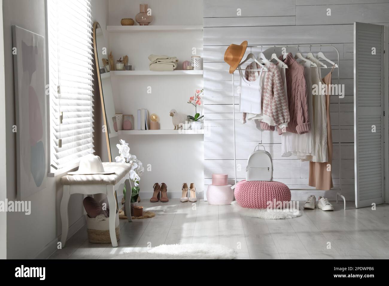 Rack with different stylish clothes, shoes and decorative elements in ...