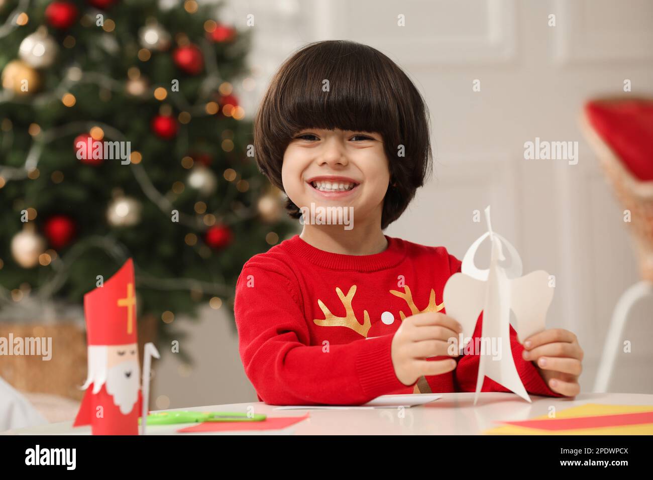 Cute little boy with paper angel for Saint Nicholas day at home Stock ...