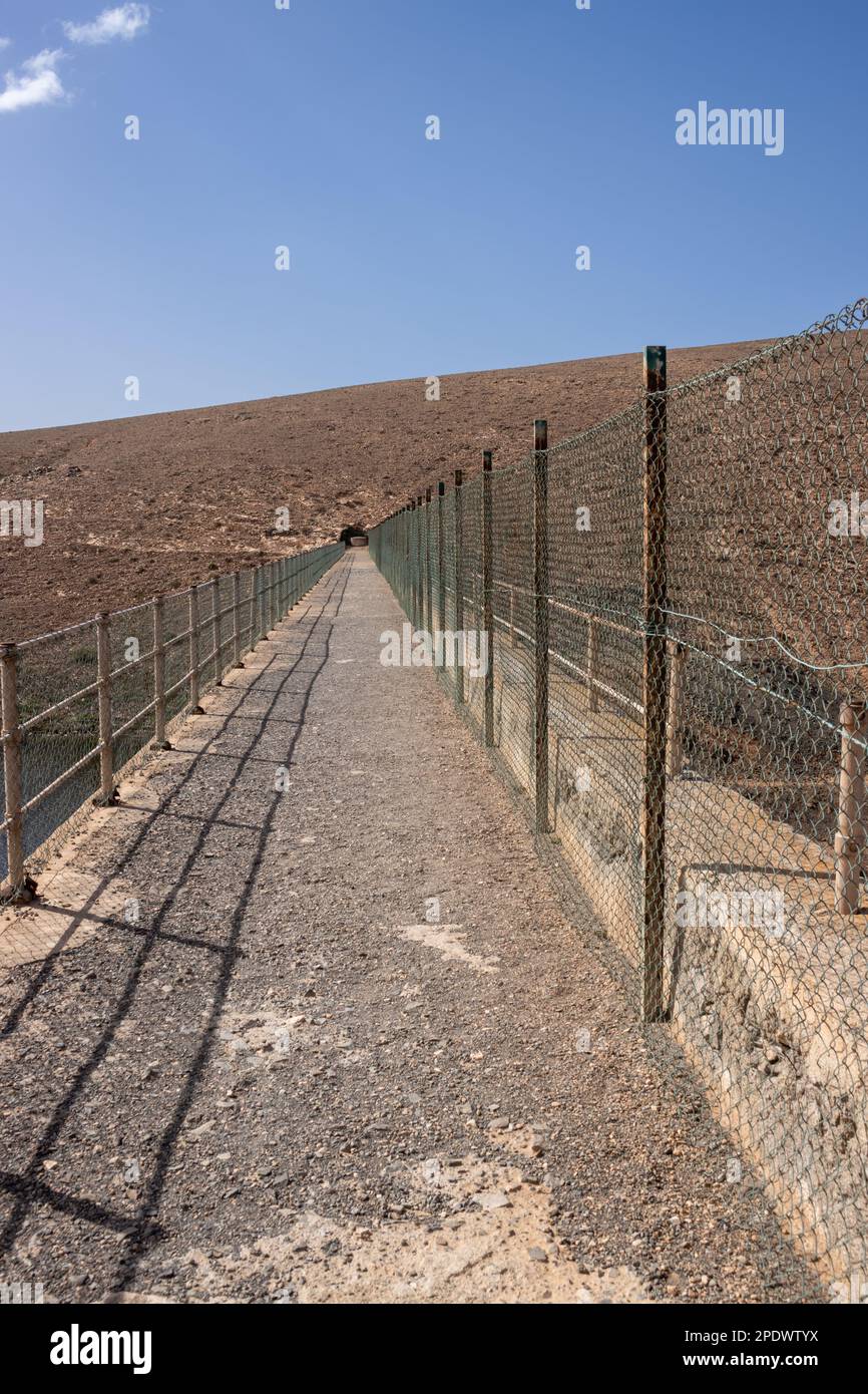 Bridge crossing the wide reservoir of a fresh water. Hill at the end ...