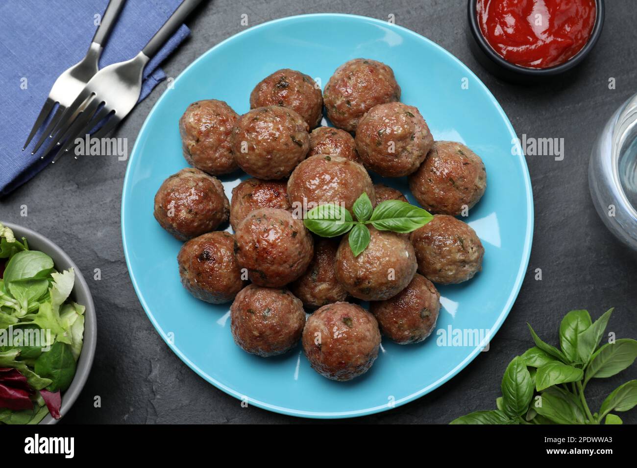 Tasty cooked meatballs with basil served on black table, flat lay Stock ...