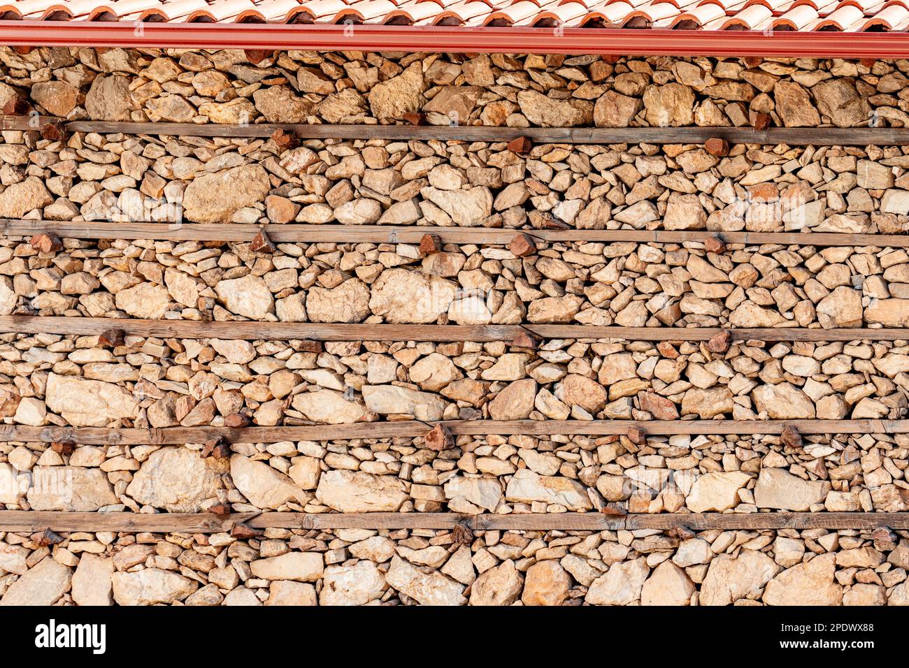 Buttoned rustical house wall made of stones and wood high in mountains ...