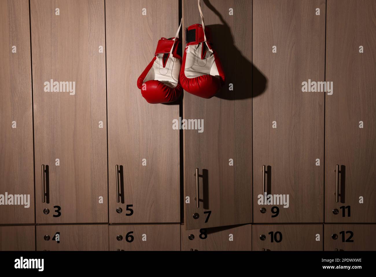 Red boxing gloves hanging on locker door in changing room Stock Photo ...