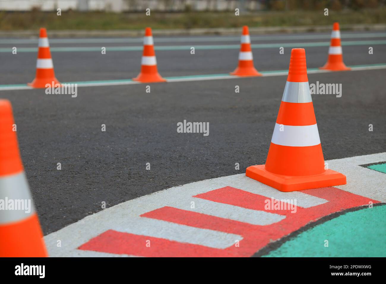 Driving school test track with marking lines, focus on traffic cone ...
