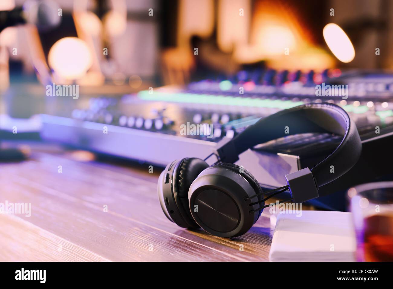 Headphones and professional mixing console on table in radio studio ...