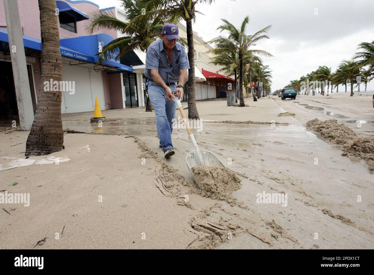 A unidentified worker shovels the sand from Fort Lauderdale, Fla. beach ...