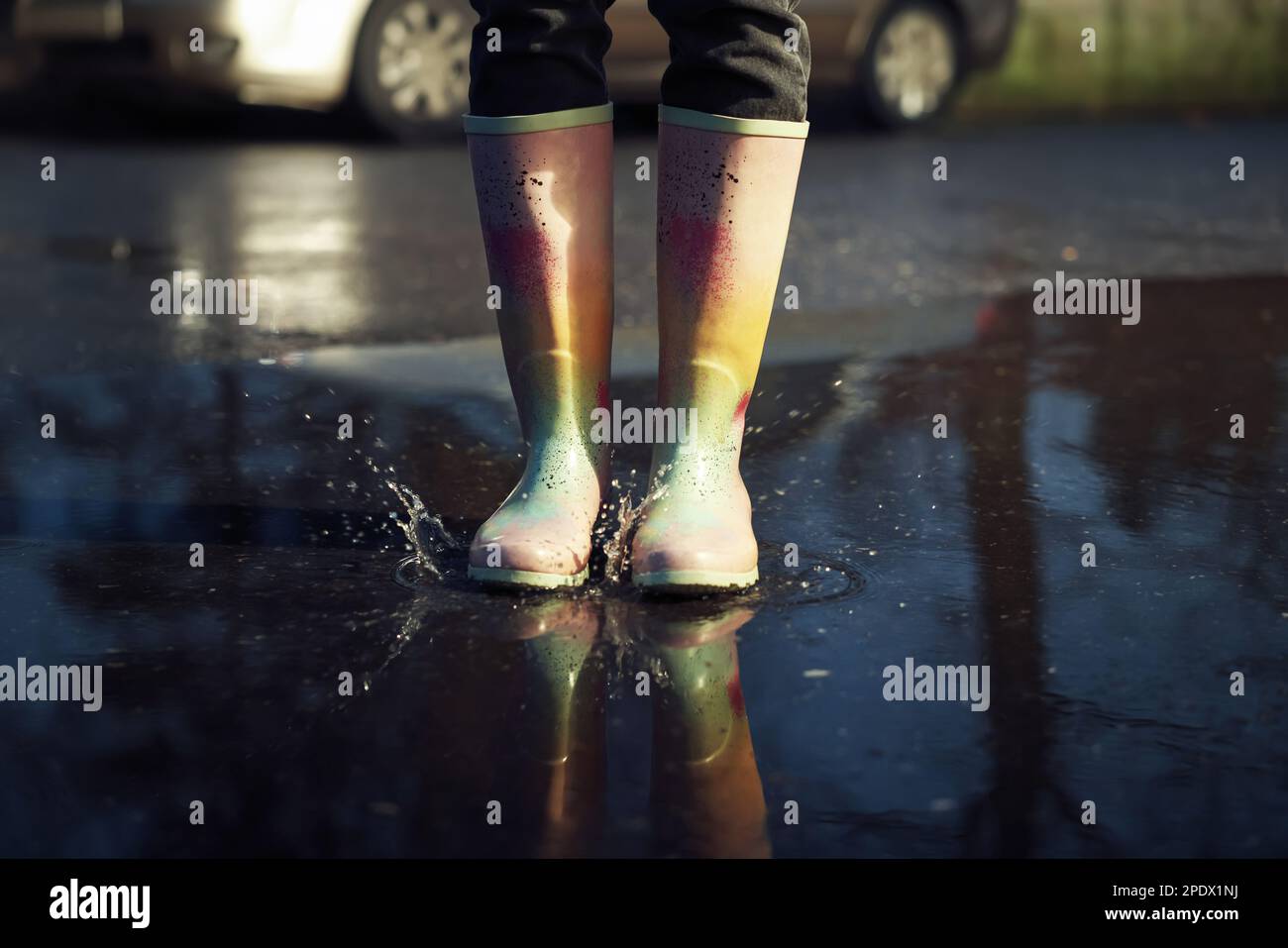 Woman with bright rubber boots in puddle, closeup. Rainy weather Stock ...