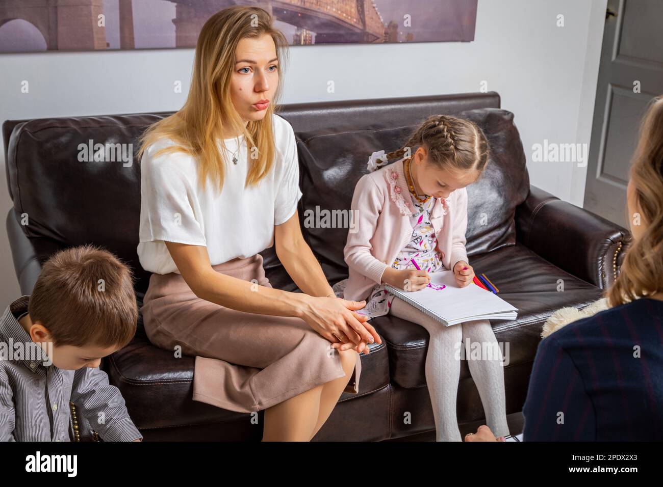 Mother with children at the reception of a psychologist, asking for ...