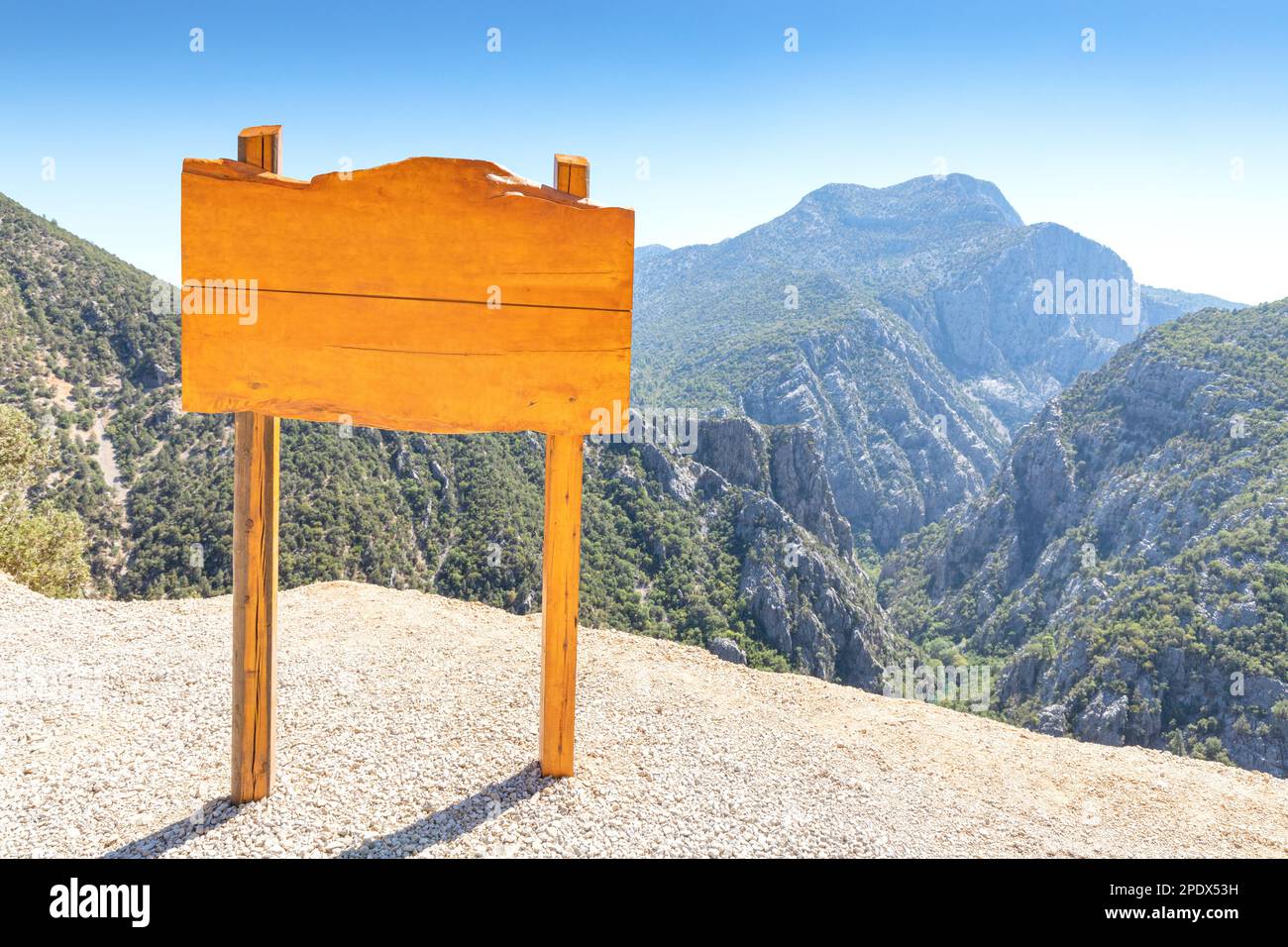 Blank wooden signpost at viewpoint against scenic mountain canyon ...