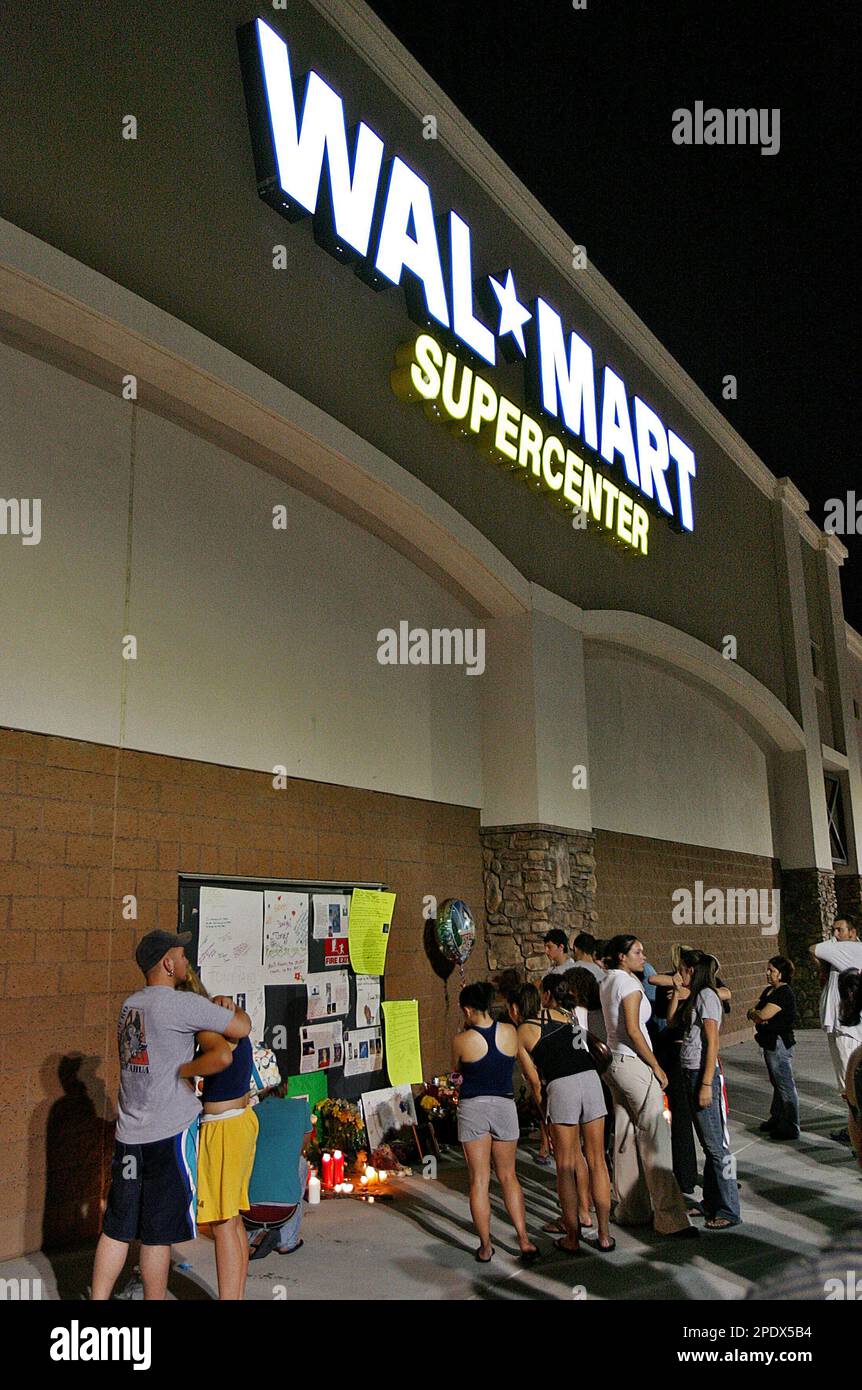 Friends embrace at a memorial to Wal-Mart employees Anthony Spangler ...