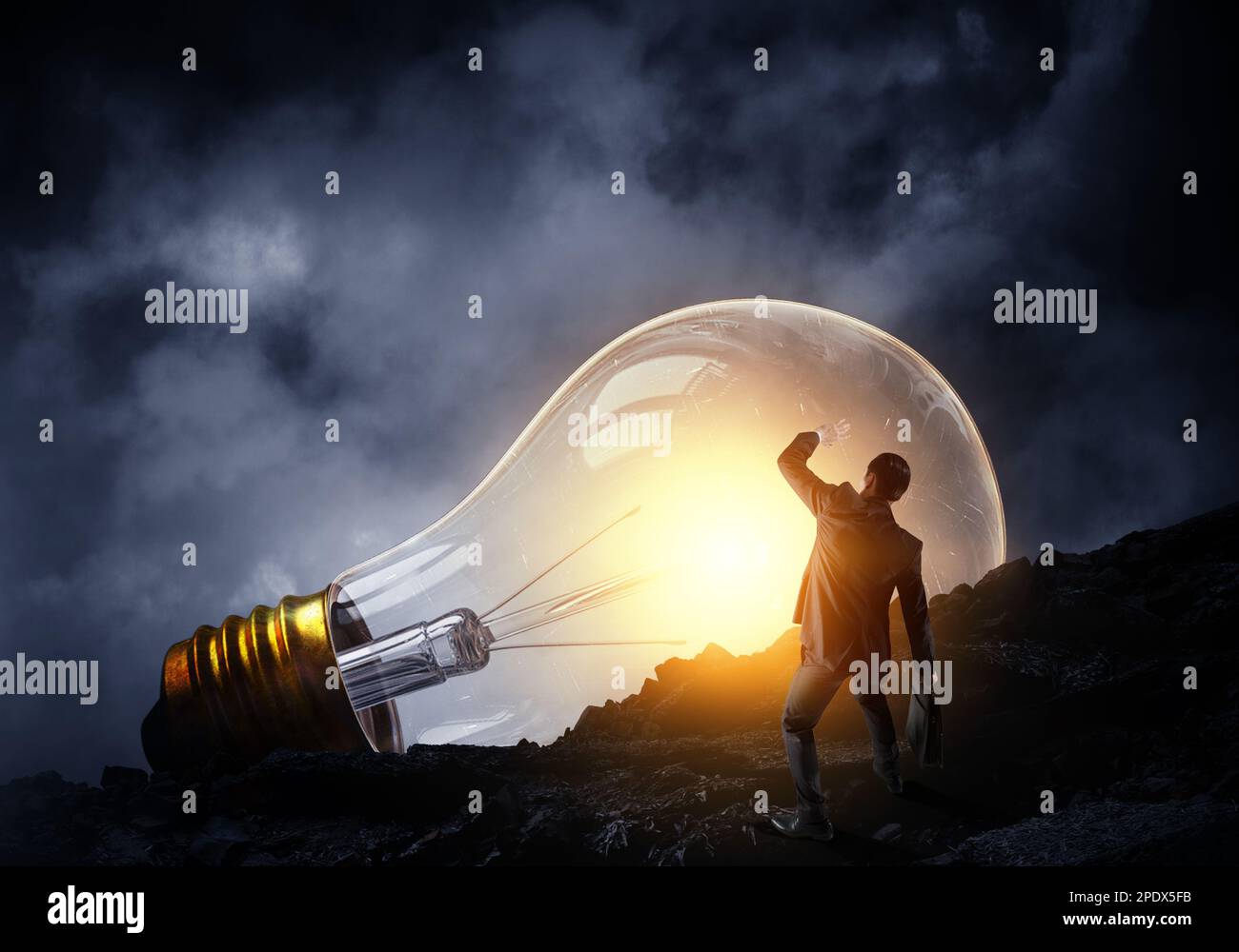 Huge light bulb glowing in the darkness Stock Photo - Alamy