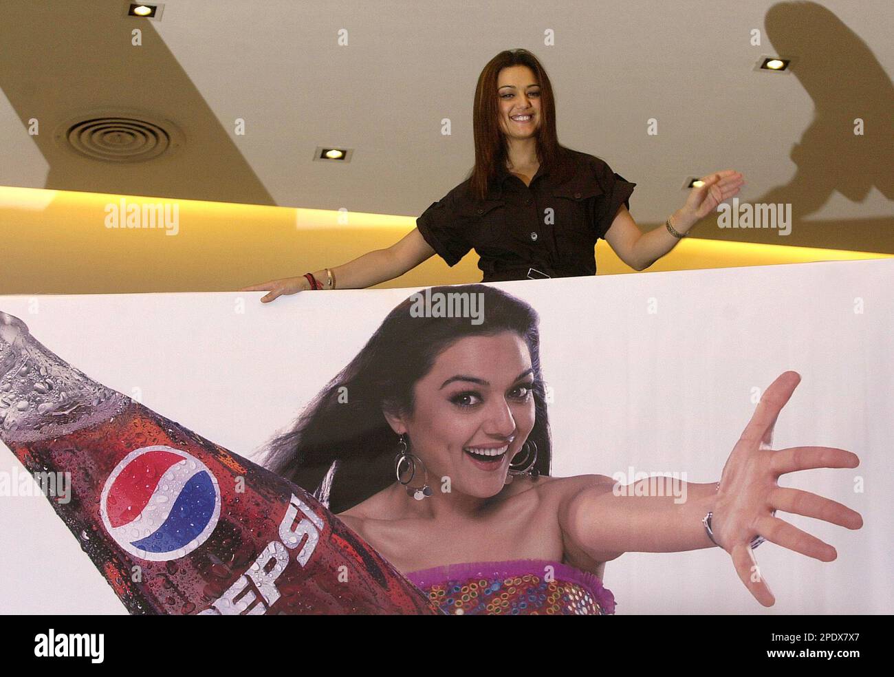 Bollywood actress Preity Zinta poses next to a poster featuring her in ...