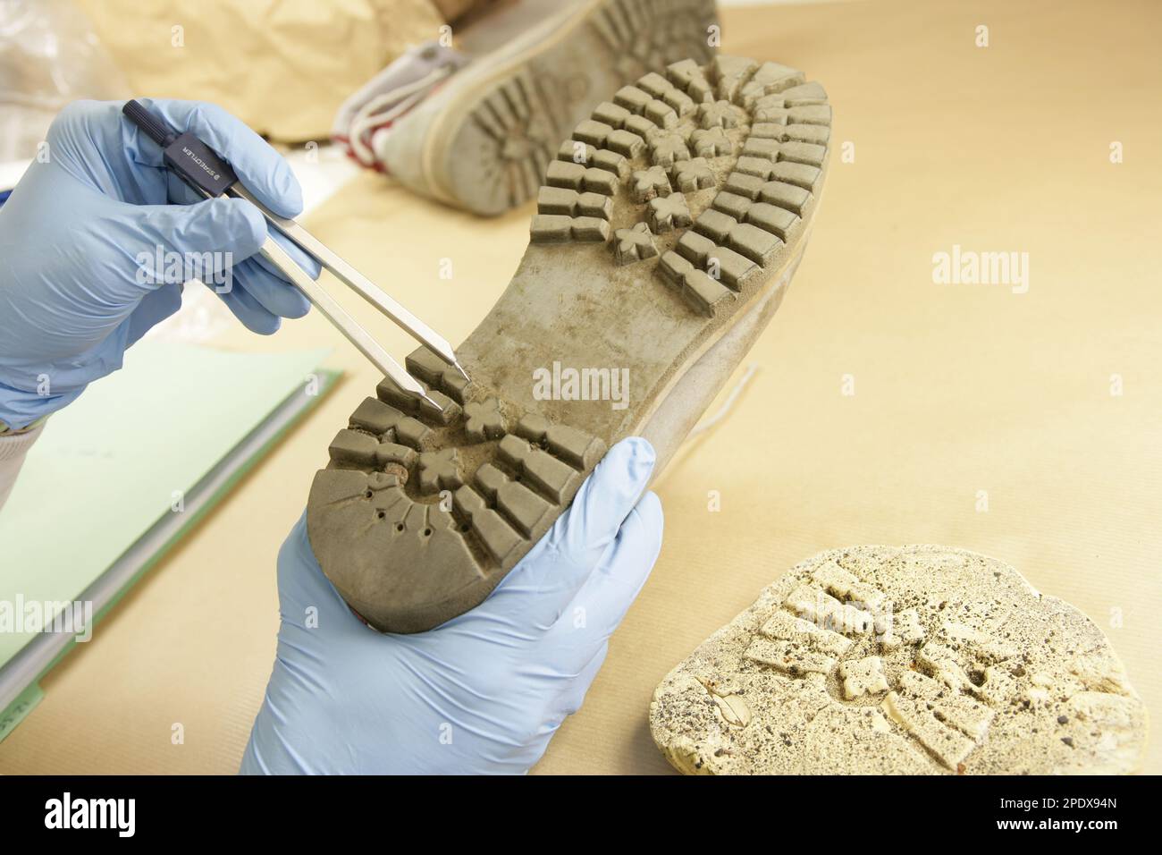 A forensic scientist matching a plaster cast of a boot print with real ...