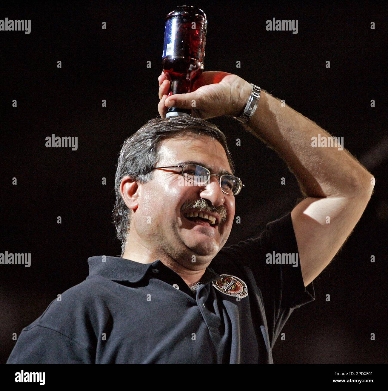 Miller Brewing President and CEO Norman Adami holds a bottle over his ...