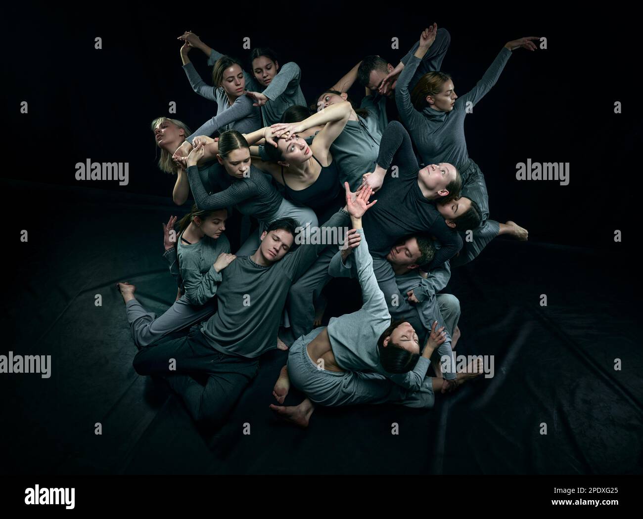 Top views of group of young people dancing contemp style against black ...