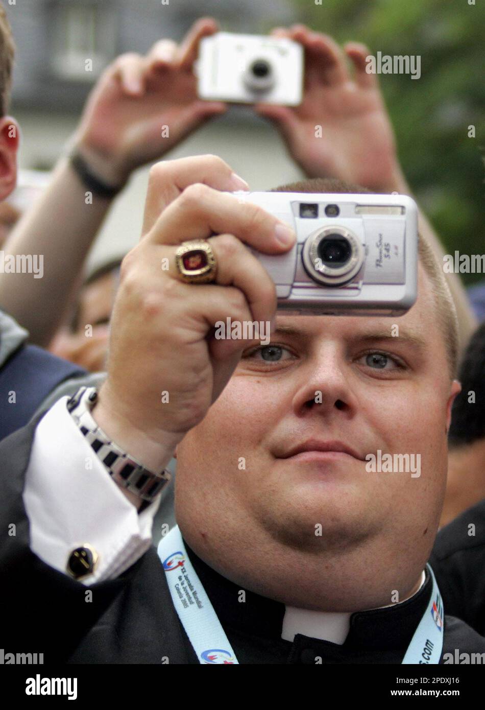 Young priests take pictures of Pope Benedict XVI at their seminary in ...